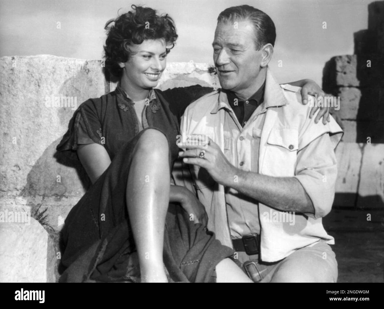 Italian screen actress Sophia Loren and American actor John Wayne relax ...