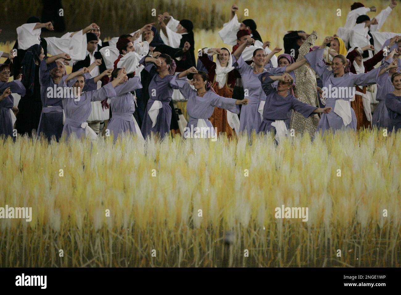Dancers perform in front of a spiral wheatfield, which in Greek ...