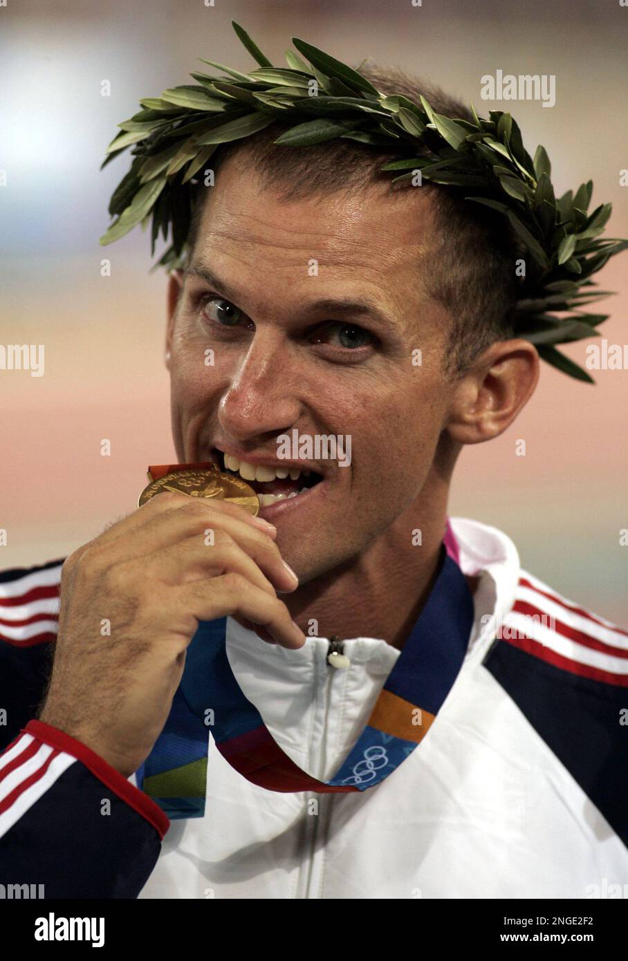 Timothy Mack of the United States bites his gold medal after the pole ...