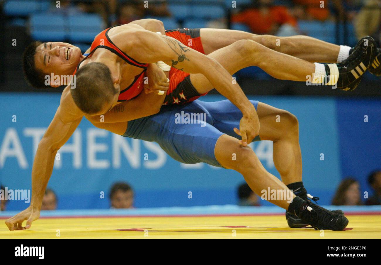 Ly Zhengyu of China, blue, and Stephen Abas, from USA wrestle during a ...
