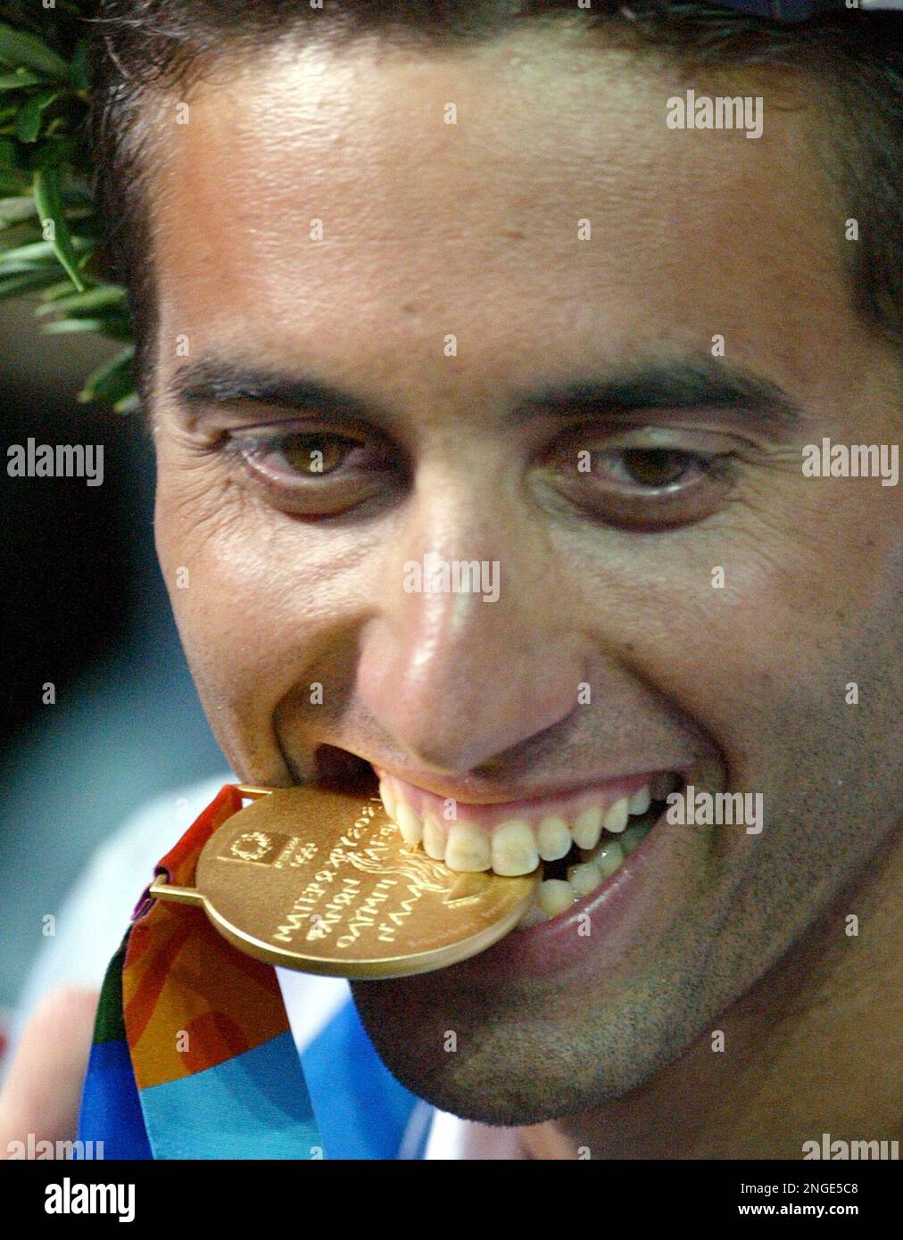 Israel's Gal Fridman bites his gold medal after the Men's Mistral ...