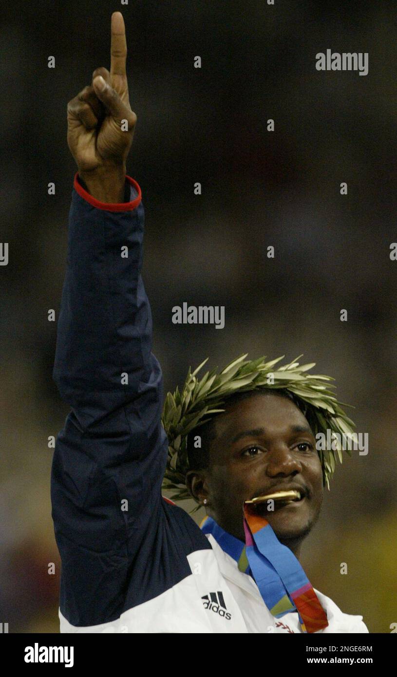 Justin Gatlin of the US bites his men's 100 meters gold medal during a ...