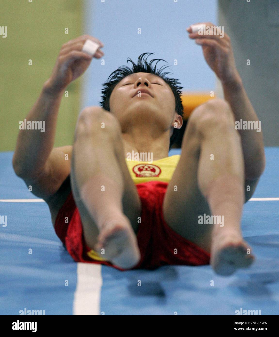 China's Li Xiaopeng reactas aftre he fell while competing on the vault ...