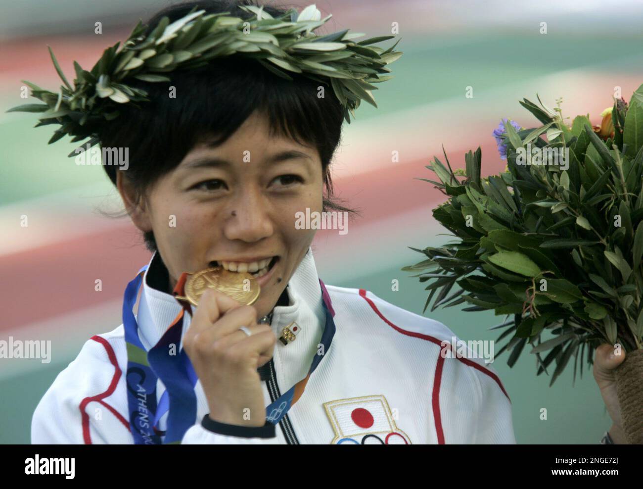 Japan's Mizuki Noguchi bites her gold medal for the women's marathon ...