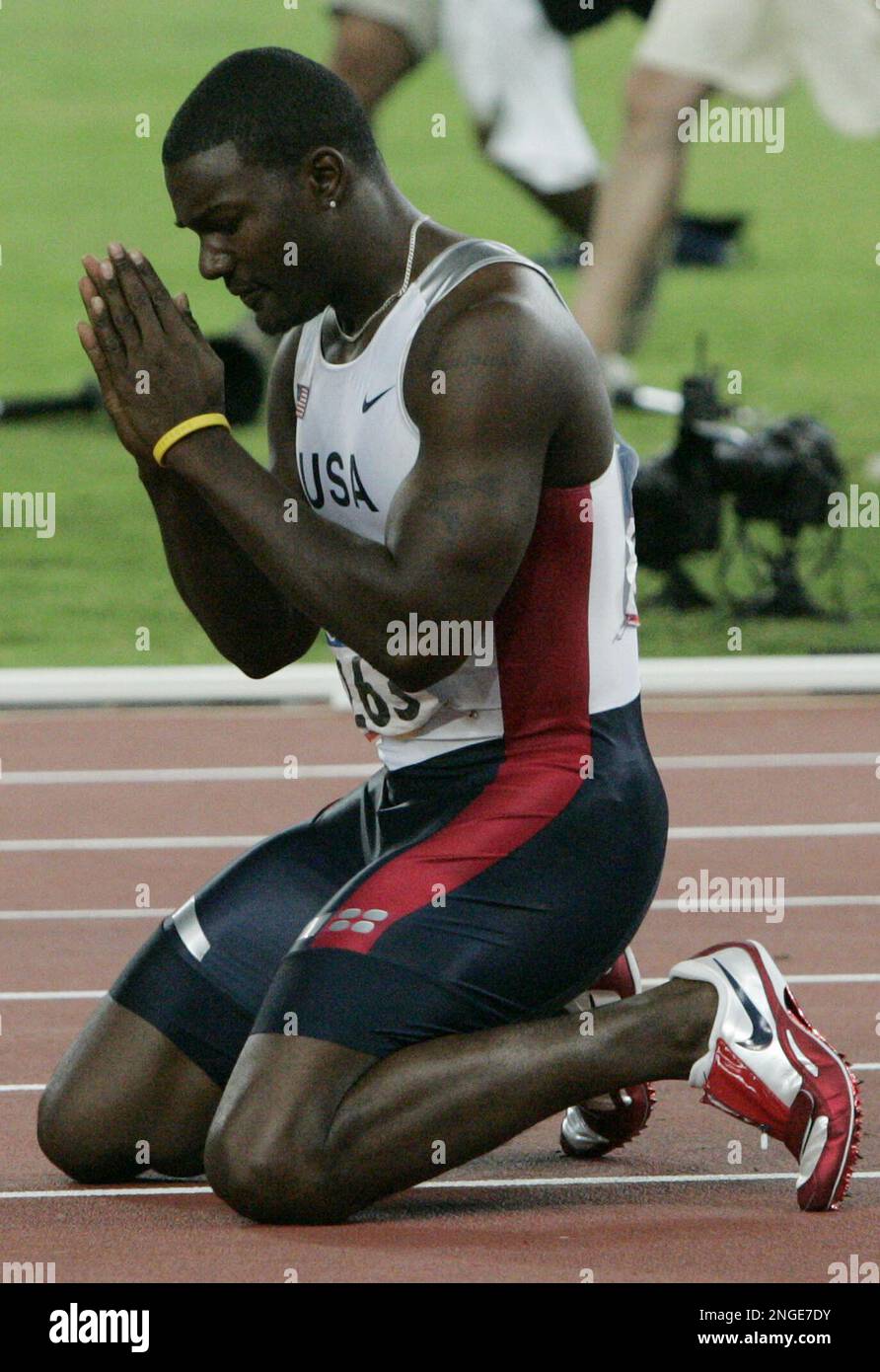 Justin Gatlin of the US prays on the track, after winning the gold ...