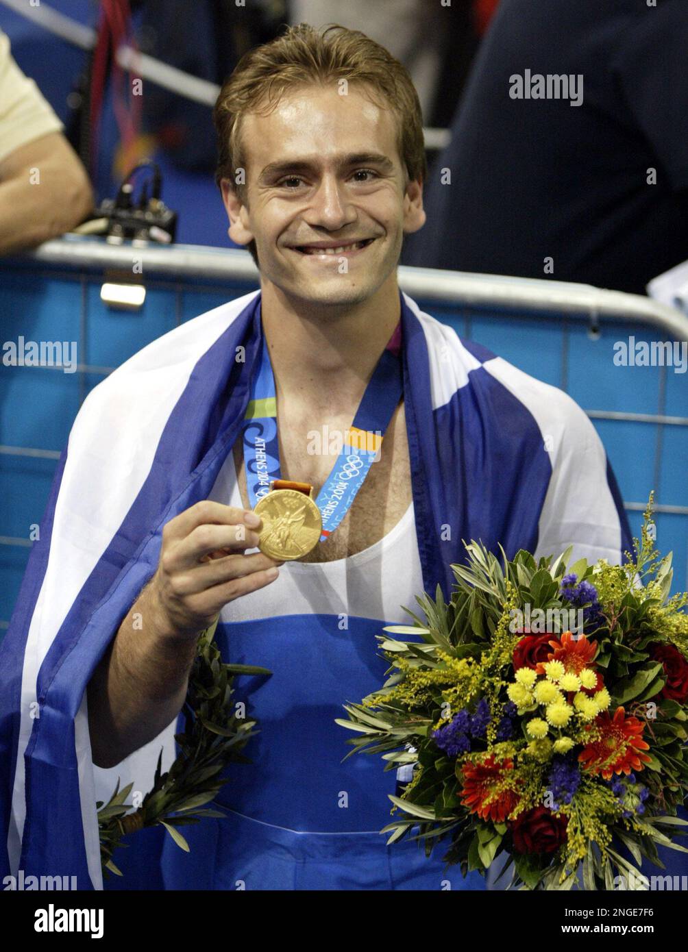 Dimosthenis Tampakos of Greece holds up his gold medal after the still rings during the men's ...
