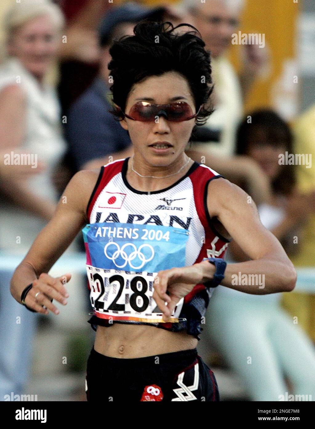 Mizuki Noguchi of Japan runs looking at her watch during the women's ...