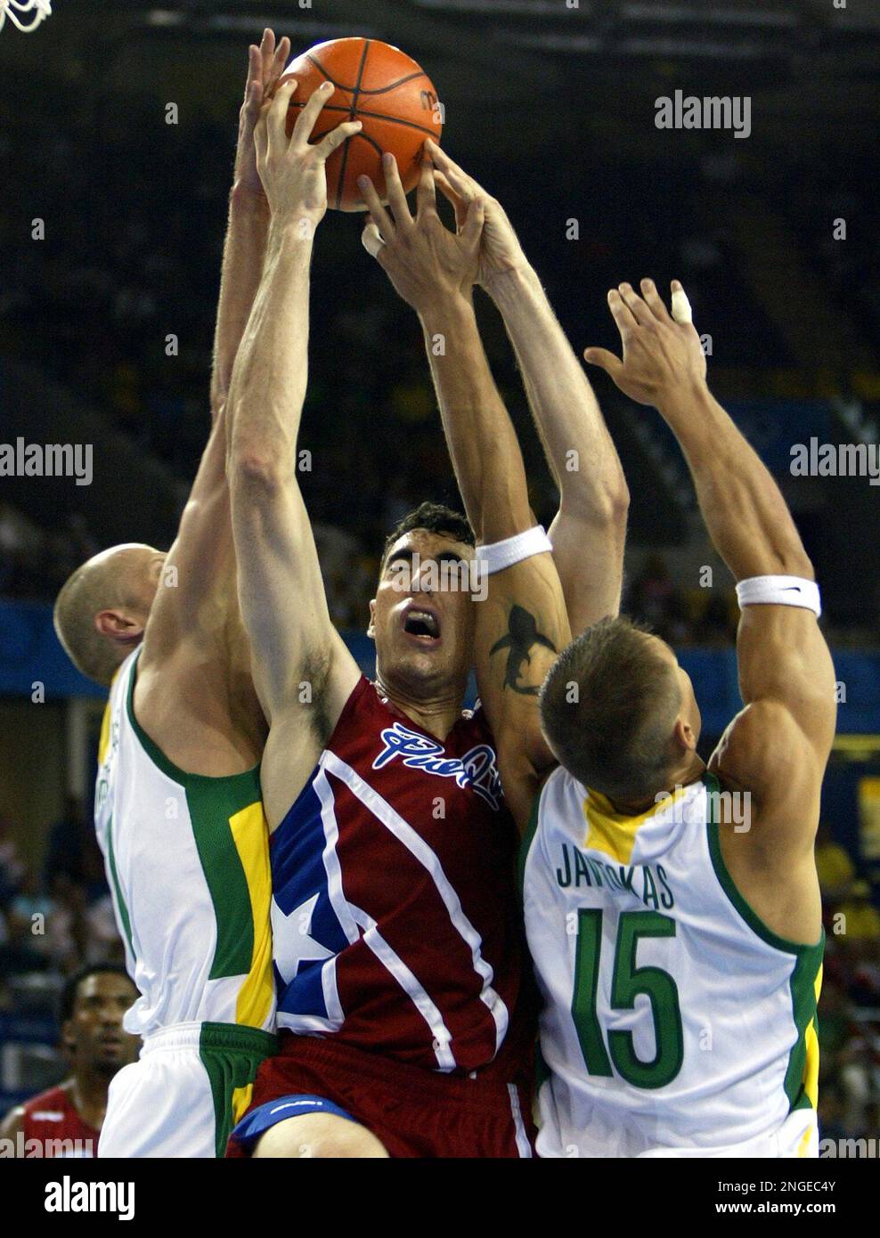 Puerto Rico's Daniel Santiago, center, is fouled by Lithuania's Saulius ...