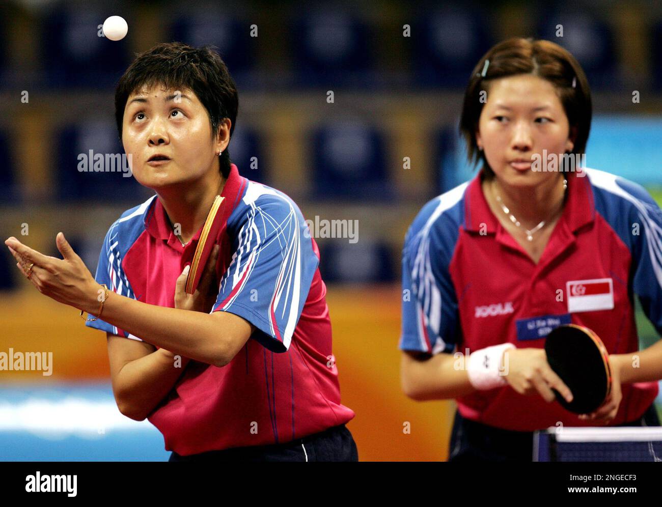Singapore's Jing Jun Hong watches the ball as she serves as her teamate ...