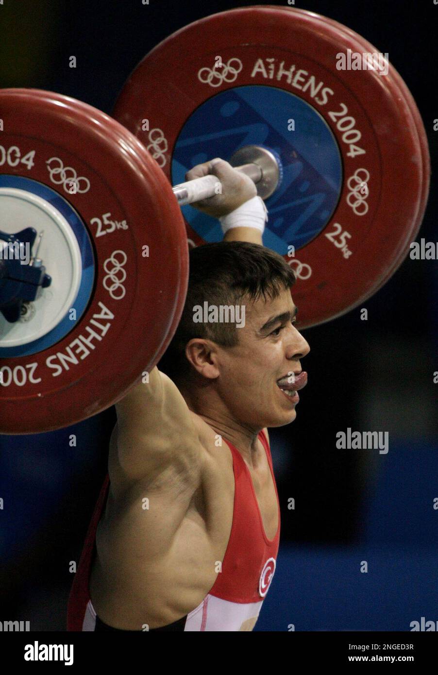 Turkish 56 kg weightlifter Halil Mutlu sticks out his tongue during his ...