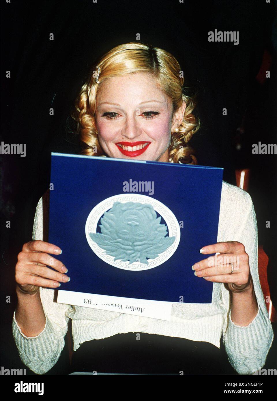 U.S. pop star Madonna smiles as she holds up the programme during ...