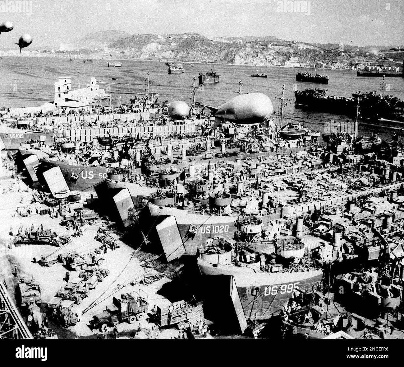 Barrage Balloons hover overhead as a line of WW II Landing Ships Tanks ...