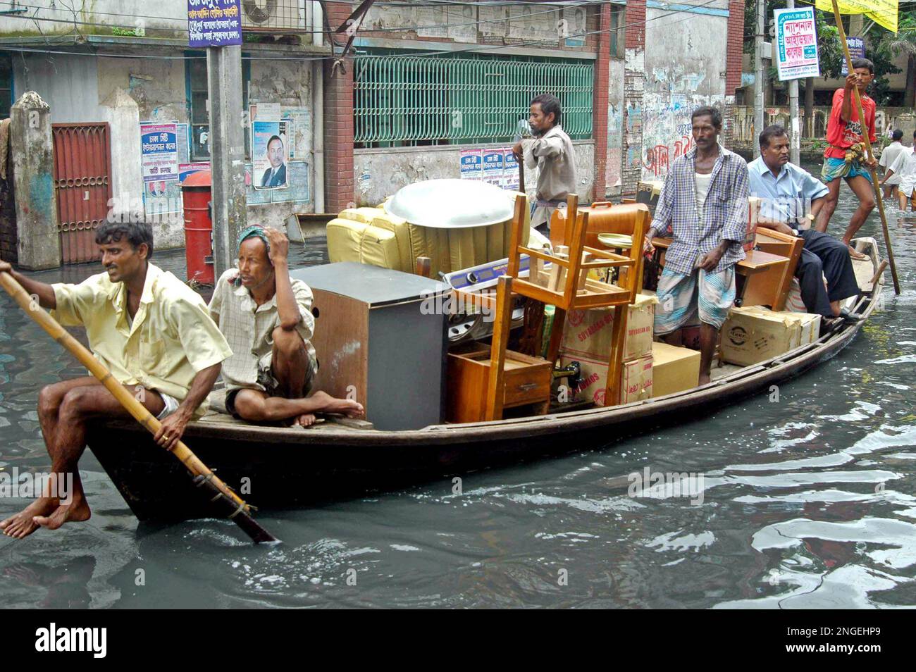 Flood victims leave with their belongings from their inundated house in ...