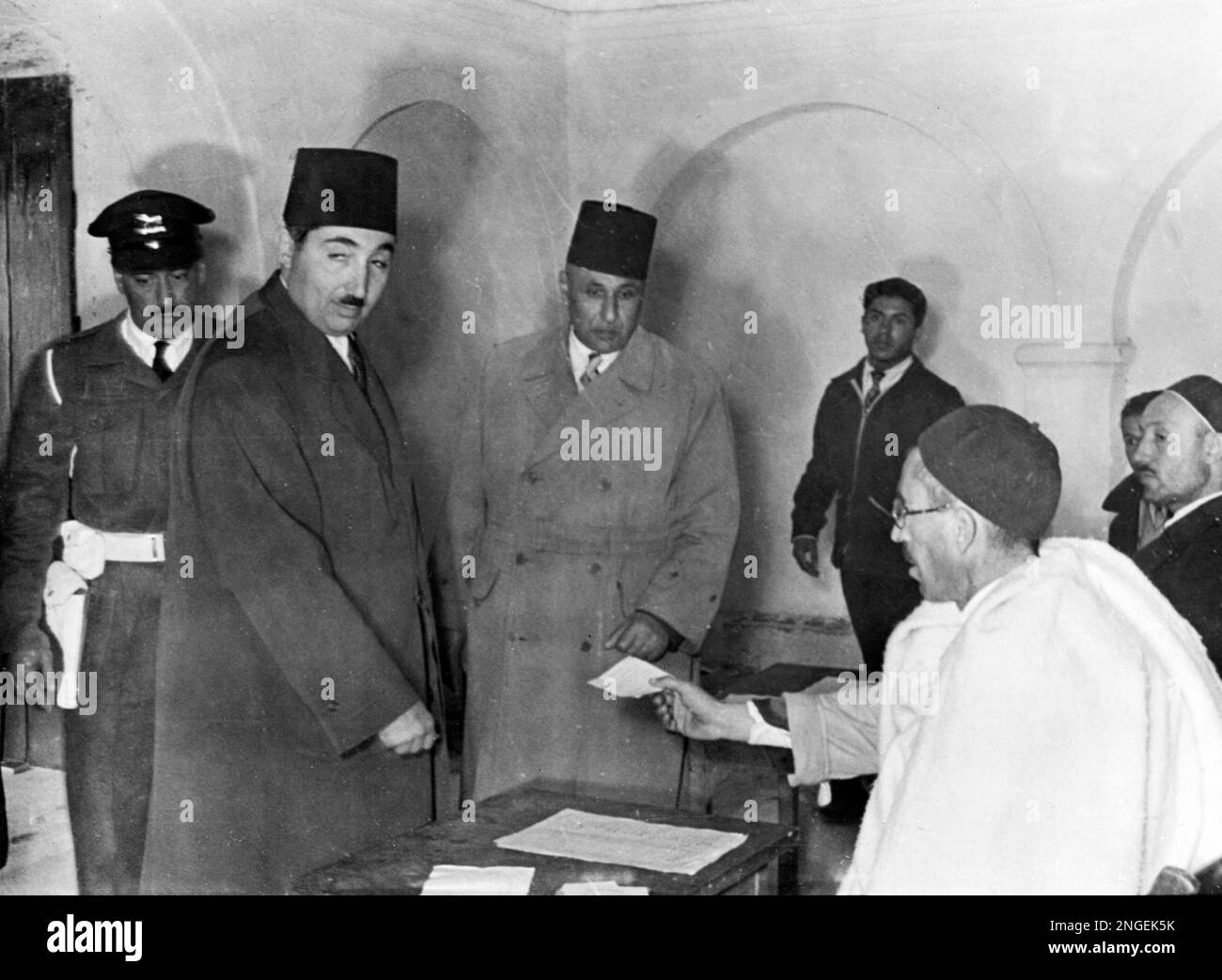 Premier Mahmoud Bey Muntasser, left, receives his ballot paper at a ...
