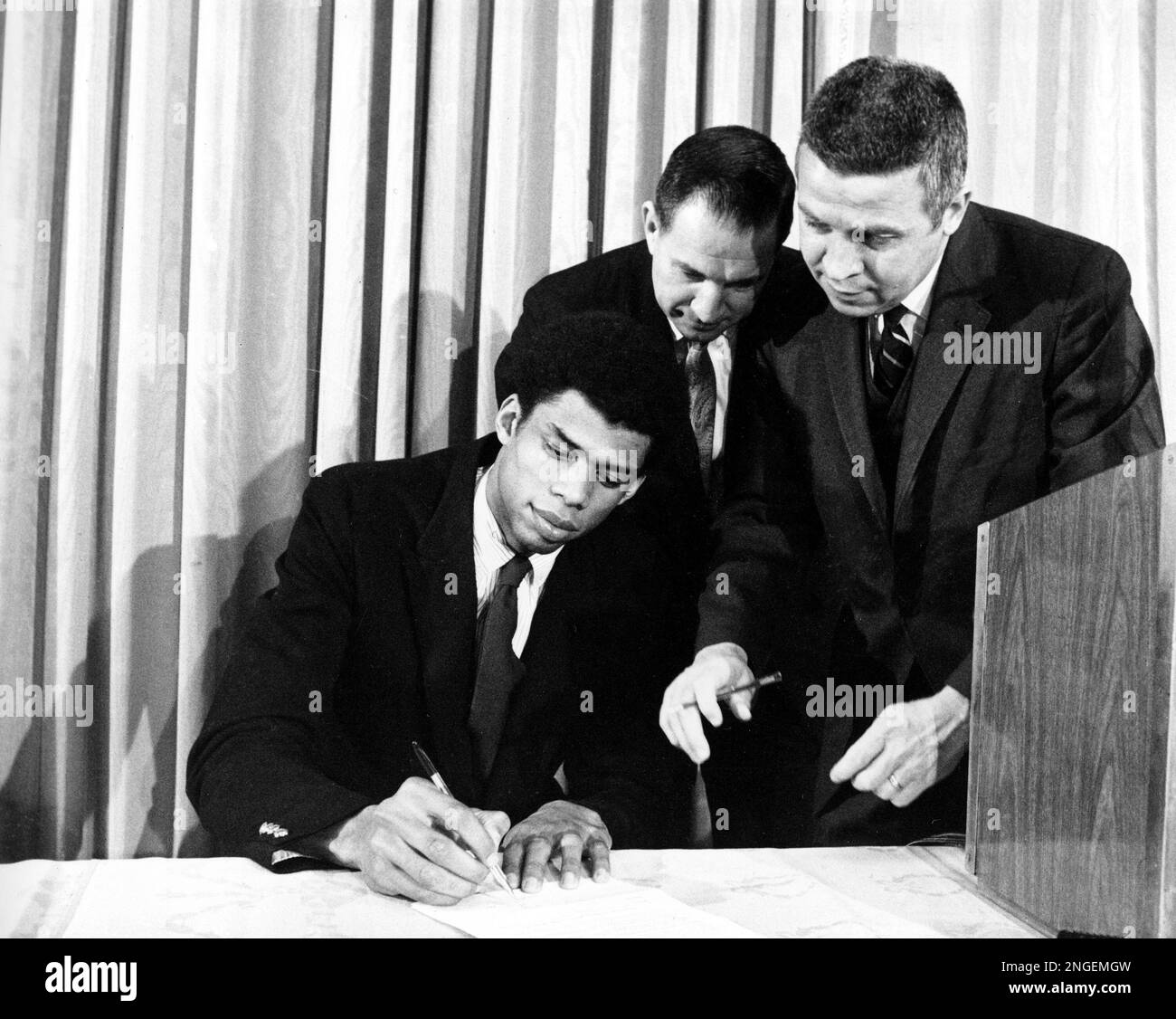 UCLA basketball star Lew Alcindor puts his signature on a professional ...