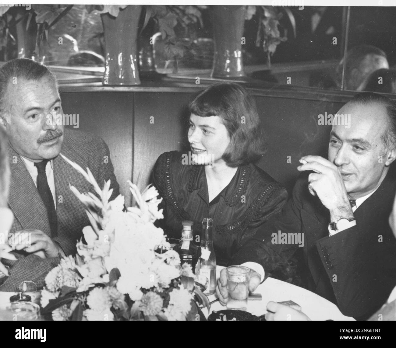 Actress Ingrid Bergman is flanked by author Ernest Hemingway, left, and ...