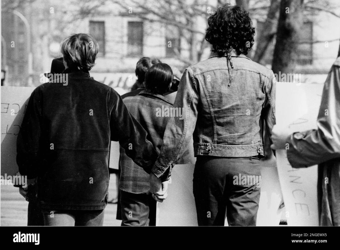 Two demonstrators clasp hands as they march with others in a picket ...