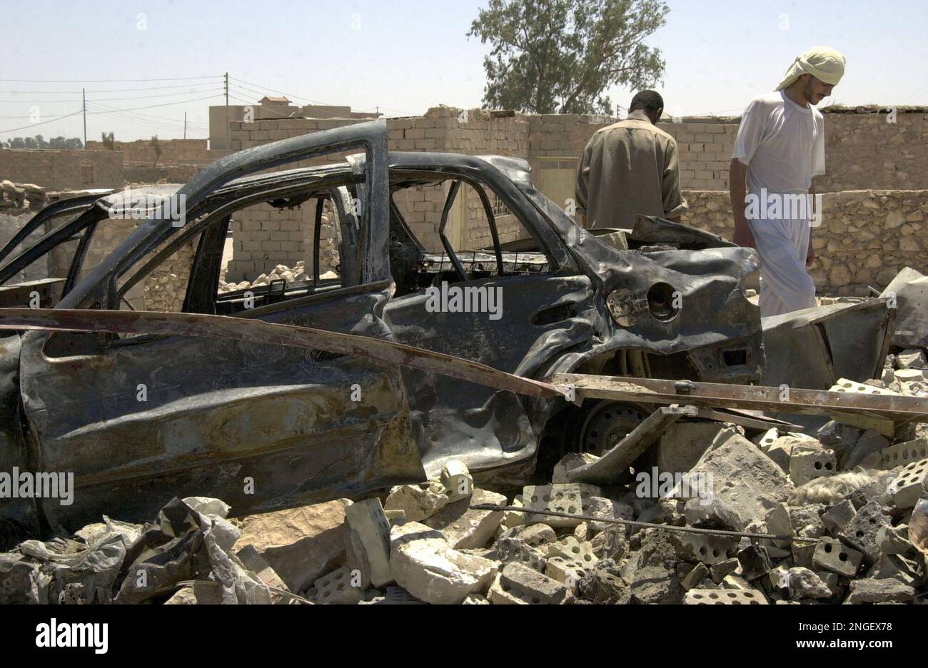 Residents of a Fallujah, Iraq neighborhood walk through the wreckage of ...