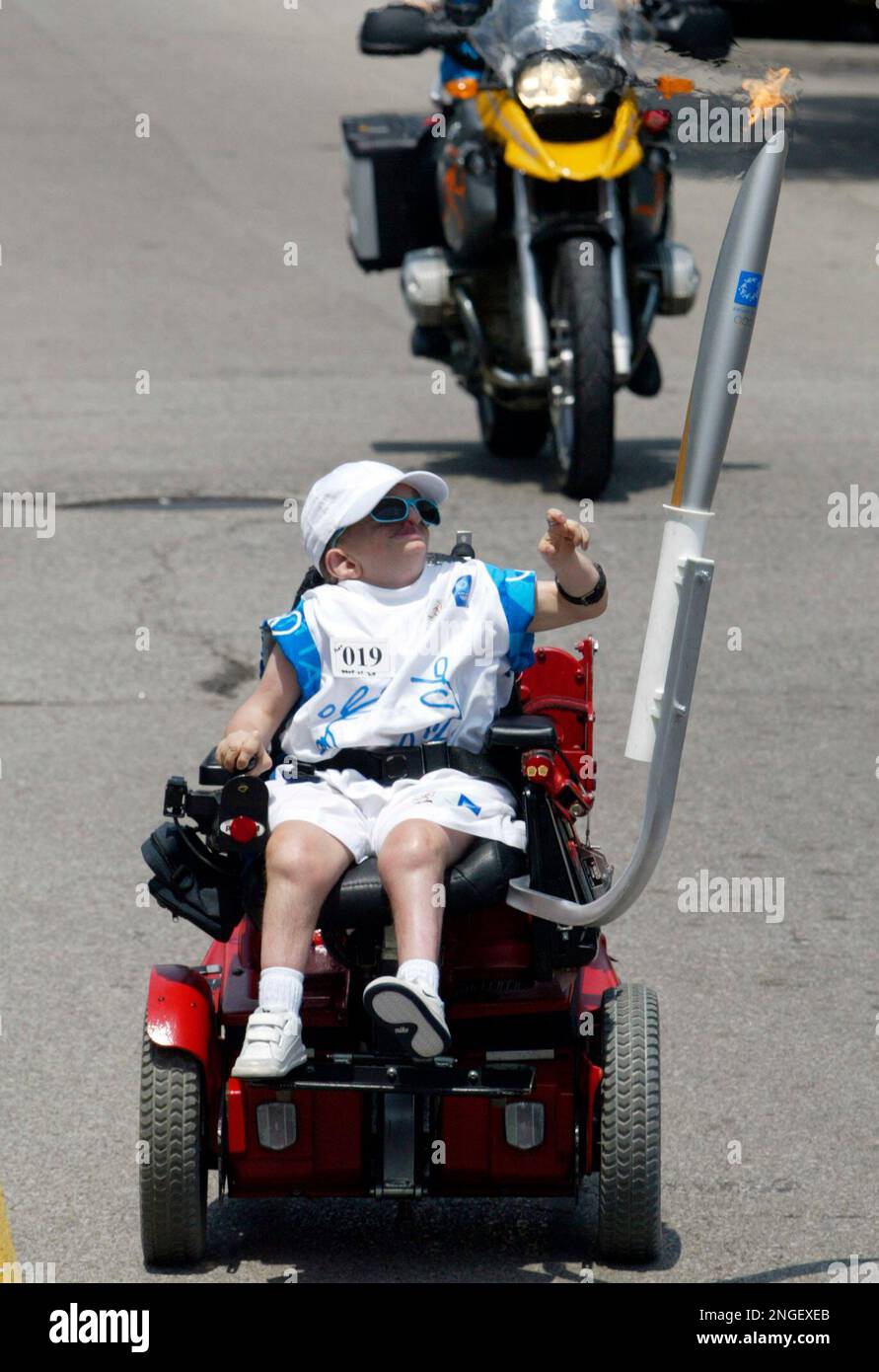 Robert Guzzo takes his turn at carrying the Olympic flame during the ...