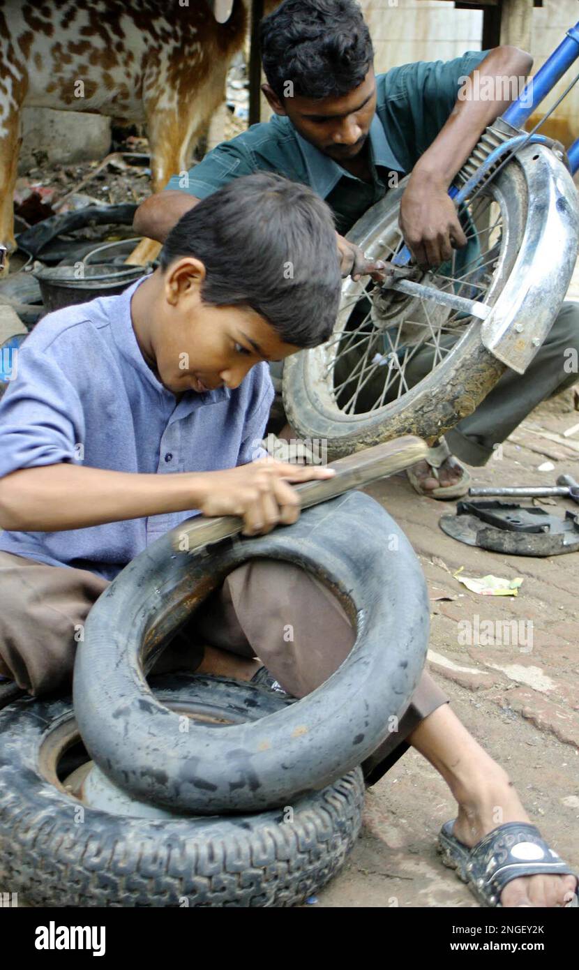 A young boy works on a tire at a garage in Allahabad, India, Friday ...