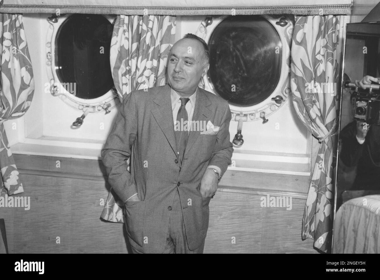 Actor Charles Boyer is photographed in his cabin aboard the Queen ...