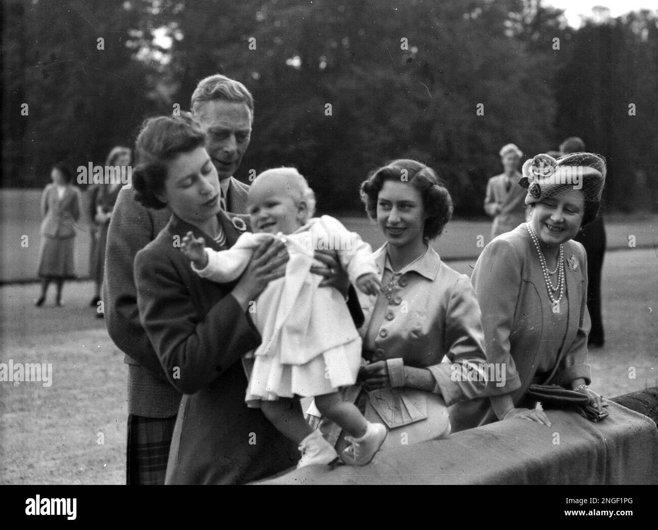 Britain's Princess Anne stands on a wall with the help of her mother ...