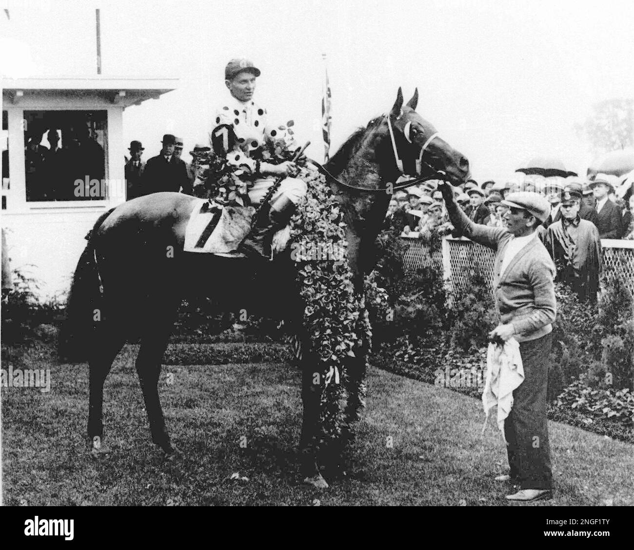 Gallant Fox, with jockey Earl Sande up, wears the roses after winning ...