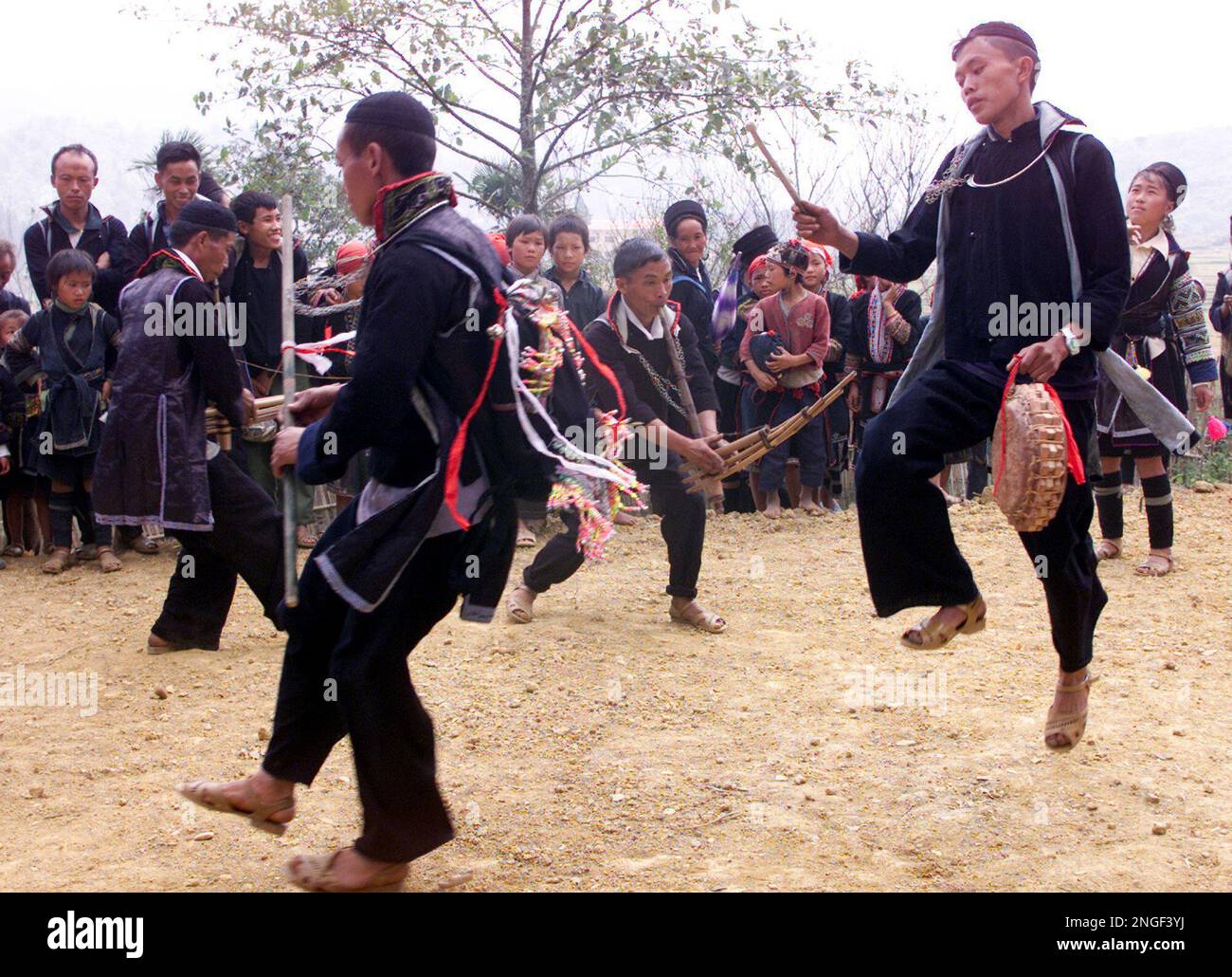 Hmong men dance and play traditional instruments during a performance ...