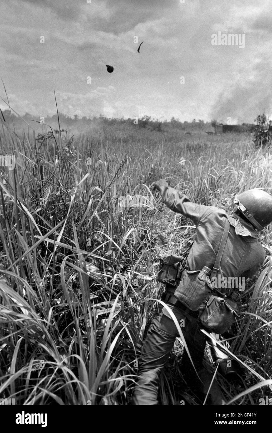 A South Vietnamese trooper throws a hand grenade into enemy bunker just ...