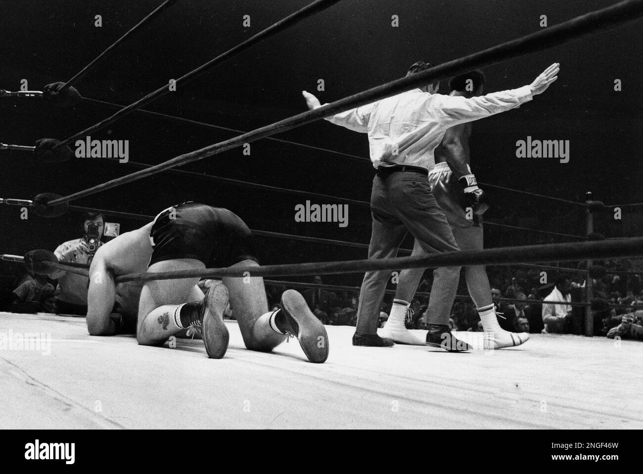 George Foreman walks away from his knocked-out opponent Boone Kirkman ...