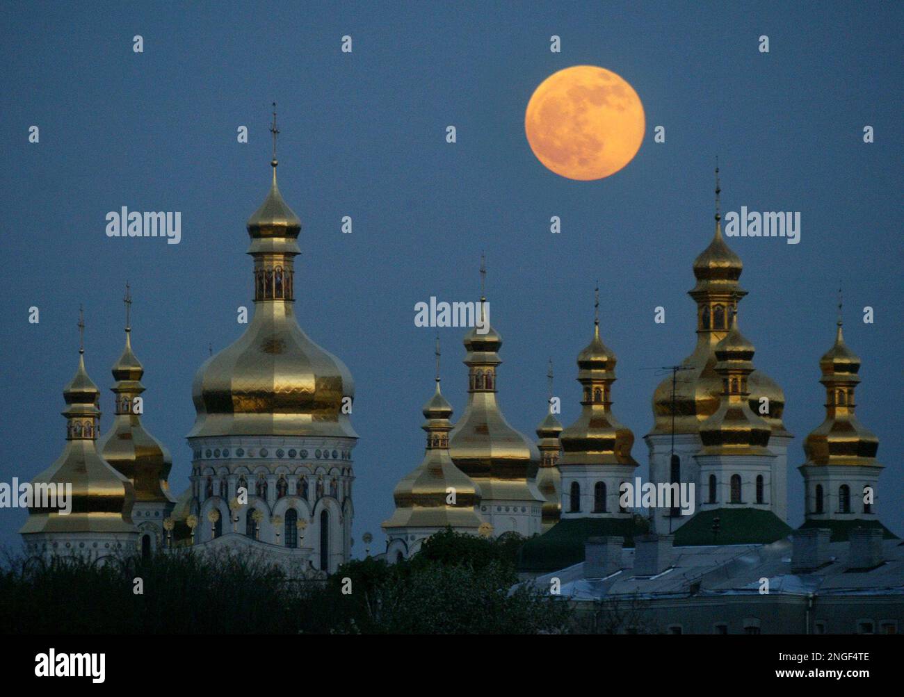 A full moon rises in the night sky during a lunar eclipse above the ...