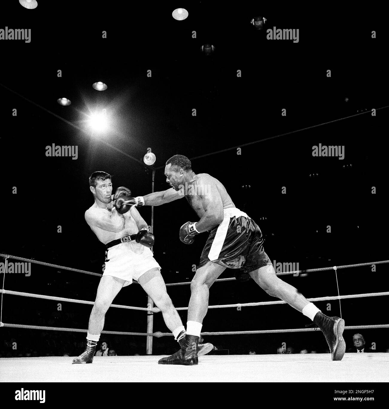 World light heavyweight champion Archie Moore, in dark trunks, lands a ...