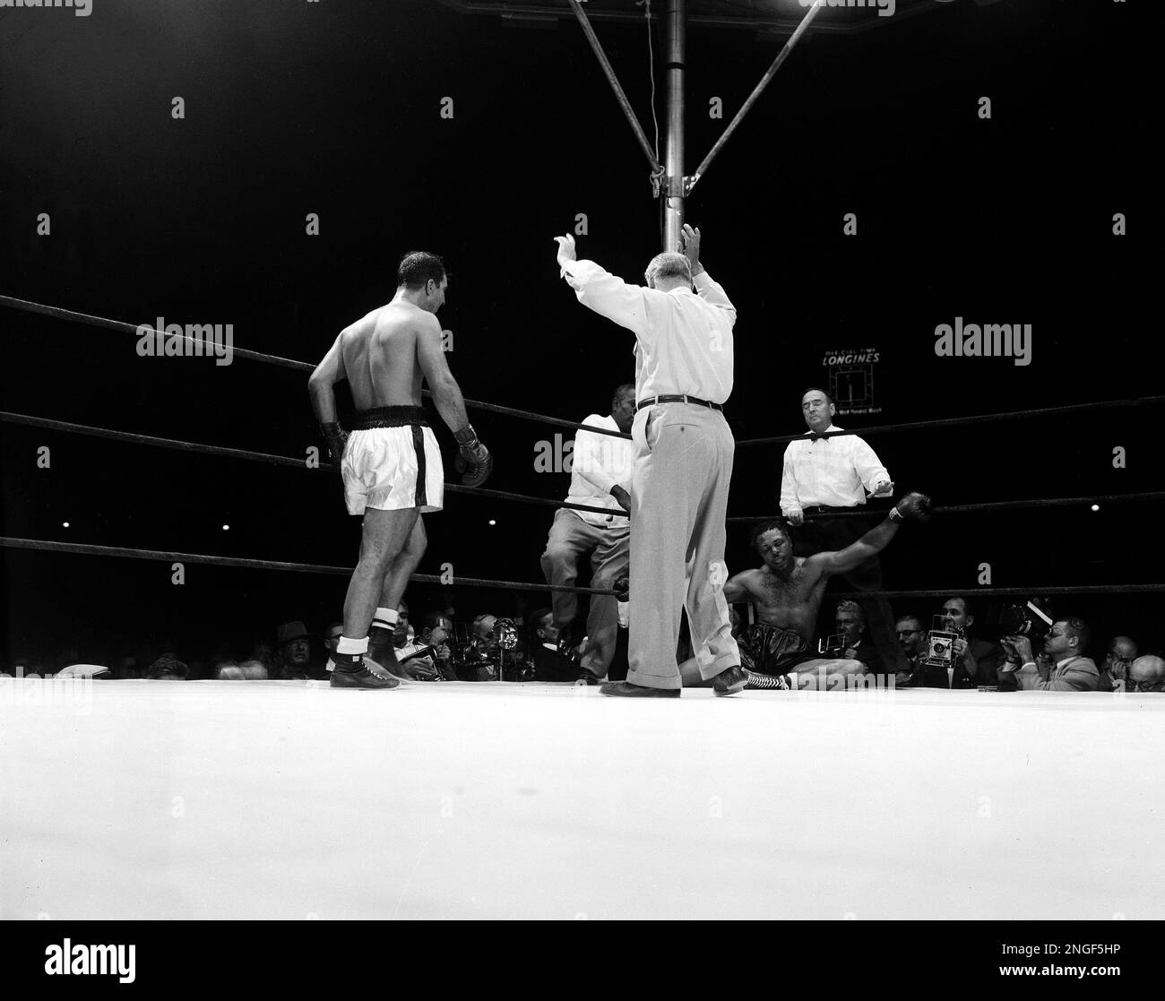 World heavyweight champion Rocky Marciano looks on as the referee ...