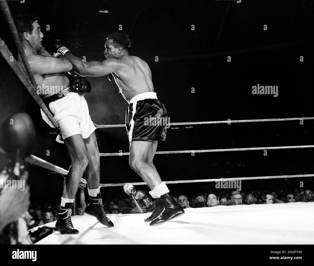 Light heavyweight champion Archie Moore, right, backs contender Joey ...
