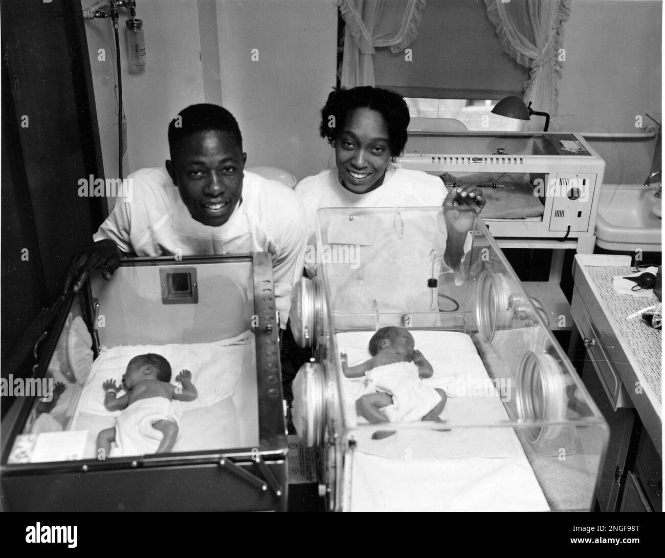 Milwaukee Braves player Hank Aaron and his wife, Barbara, pose with their one-day-old twin sons ...