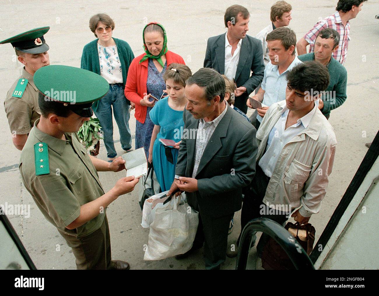 A Soviet border guard stops to look at the passport of an ethnic ...