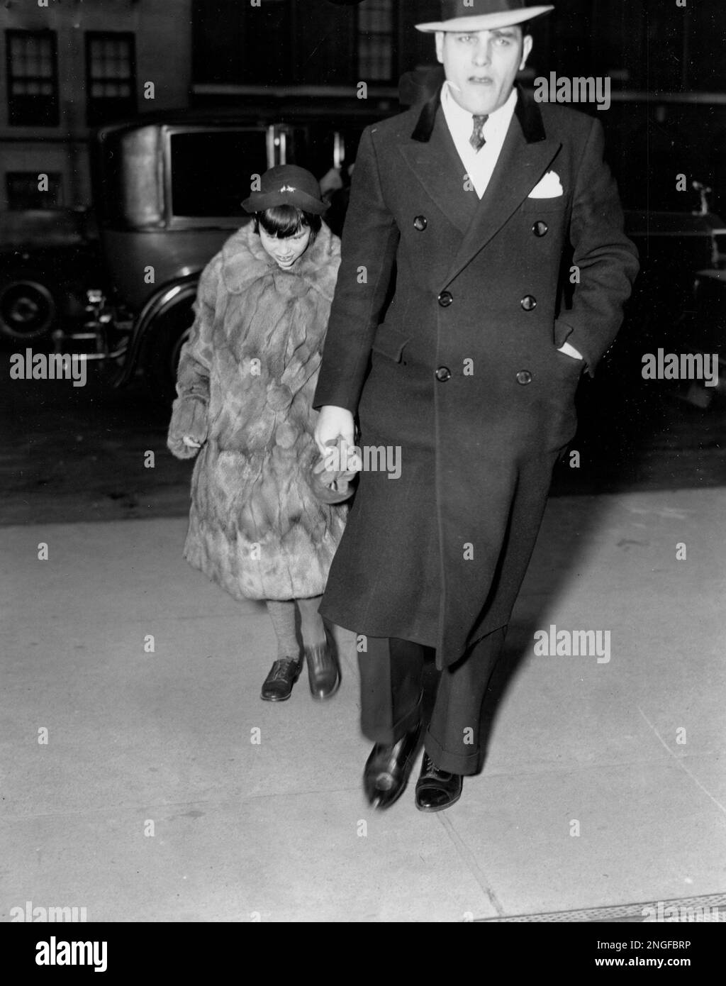 Clad in a gray squirrel fur coat, little Gloria Vanderbilt arrives at ...
