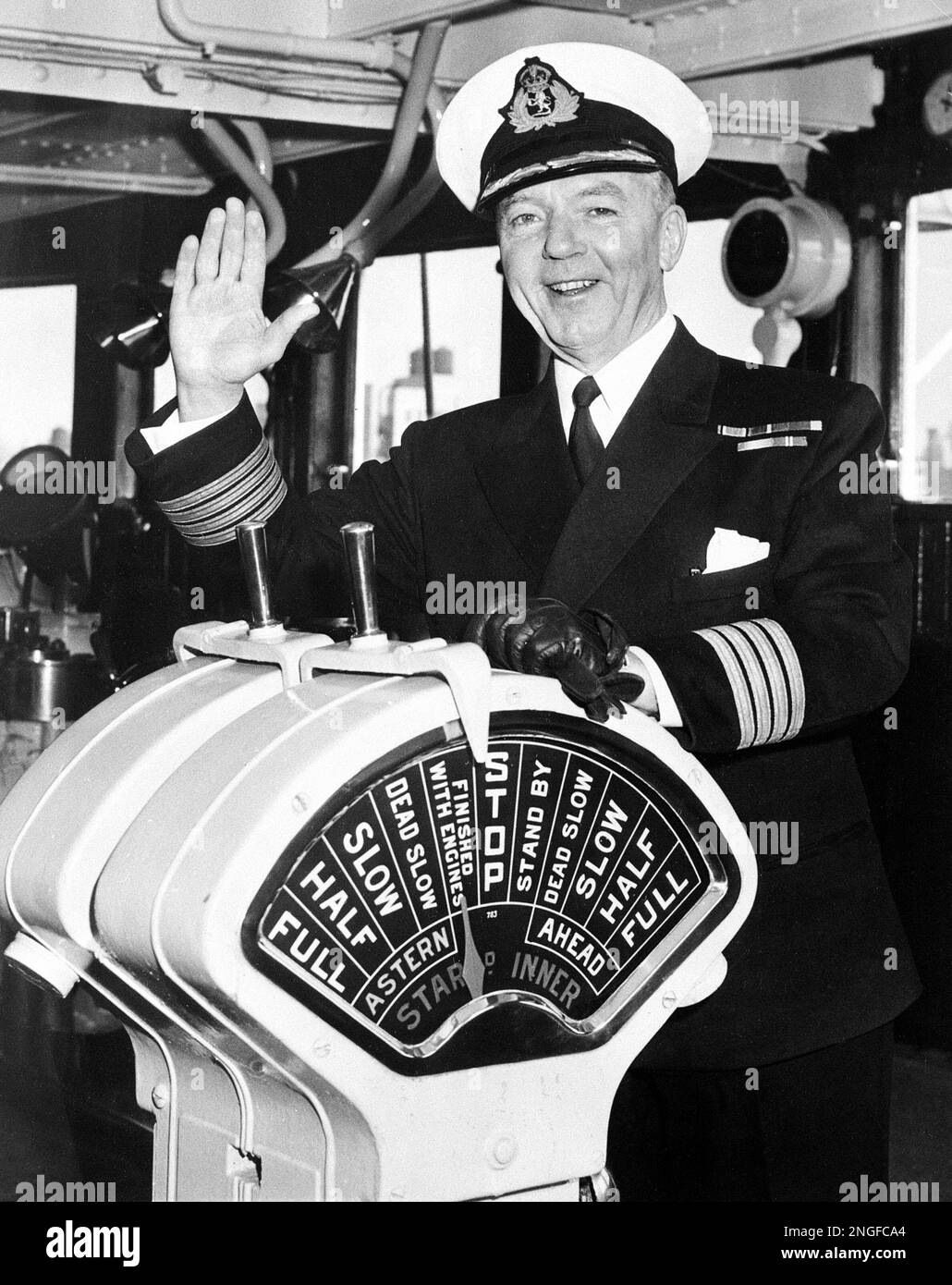 Captain Donald W. Sorrell waves from behind the engine room telegraph ...