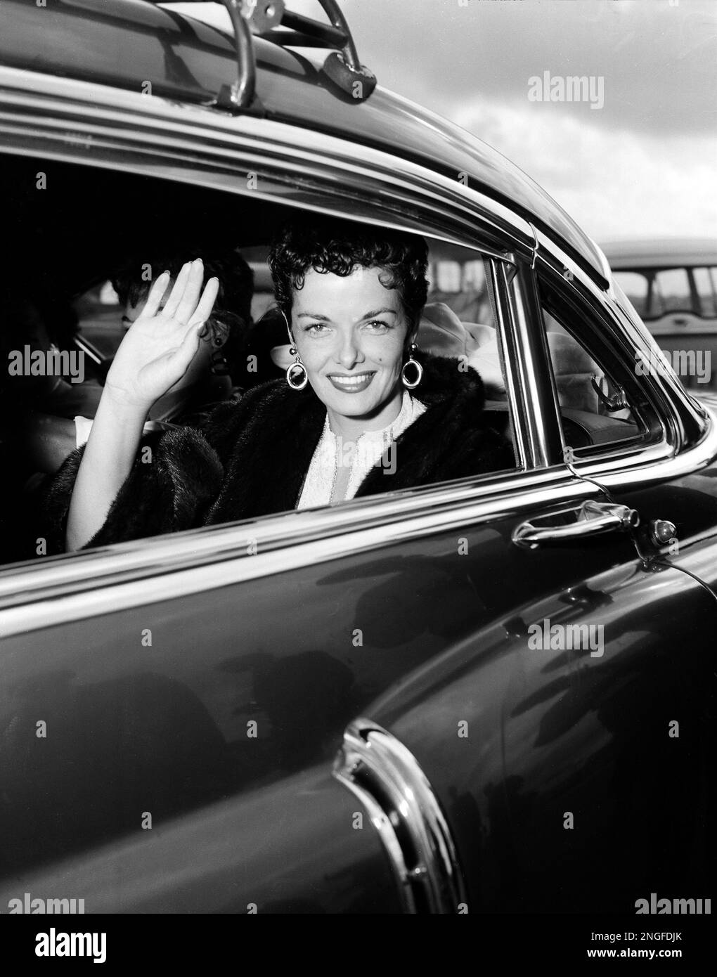 American actress Jane Russell waves at fans and journalists as she ...