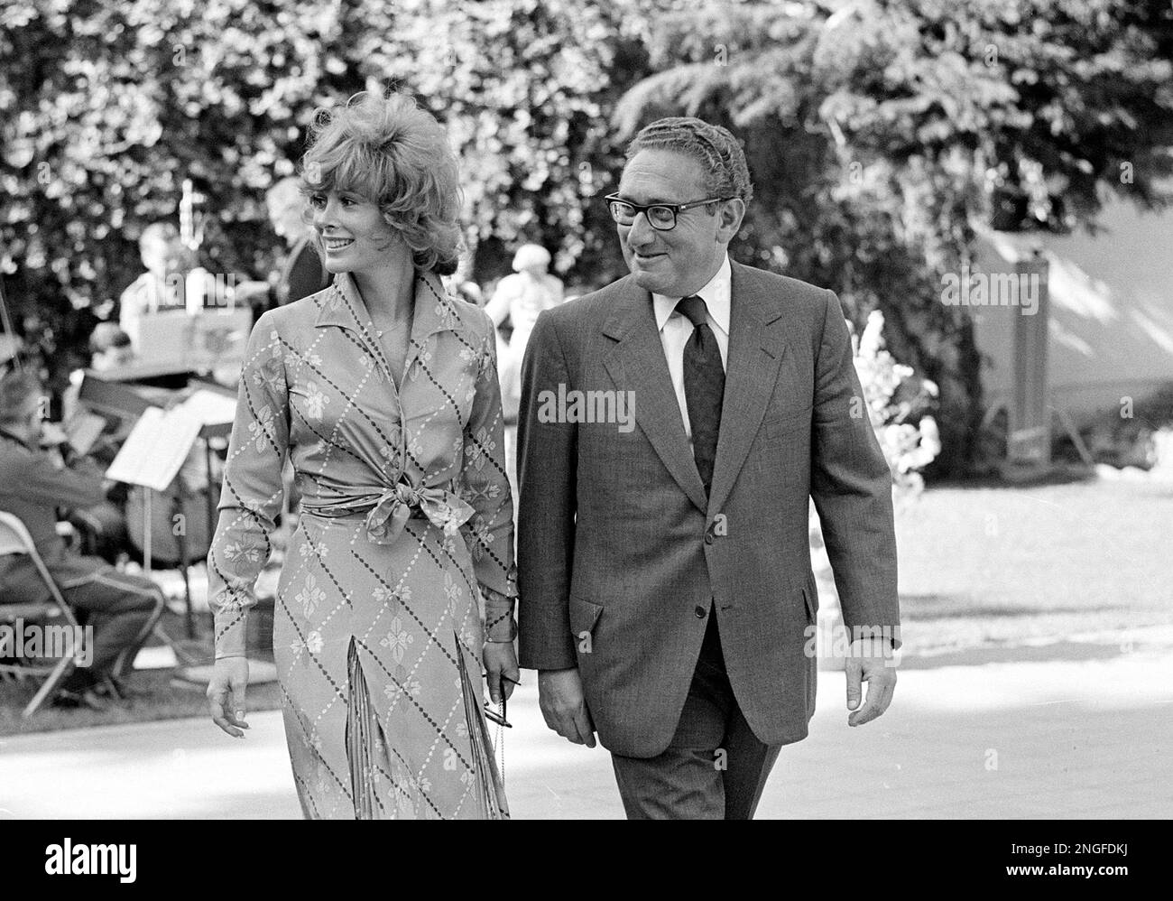 U.S. Secretary of State Henry Kissinger walks alongside of actress Jill ...