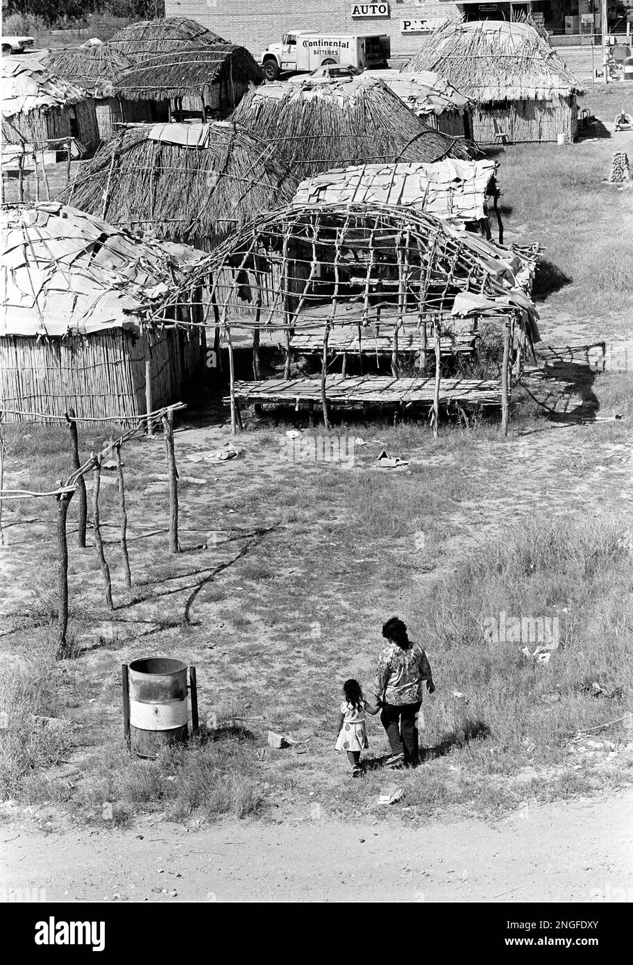 A woman walks with her daughter toward the makeshift homes at Kickapoo ...