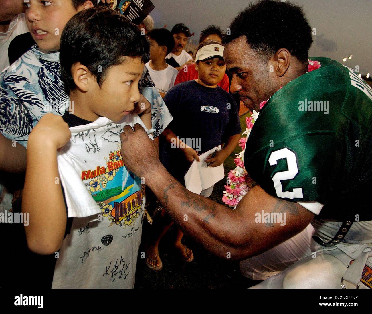Aina Running back Fred Russell of Iowa autographs a Hula Bowl shirt for ...