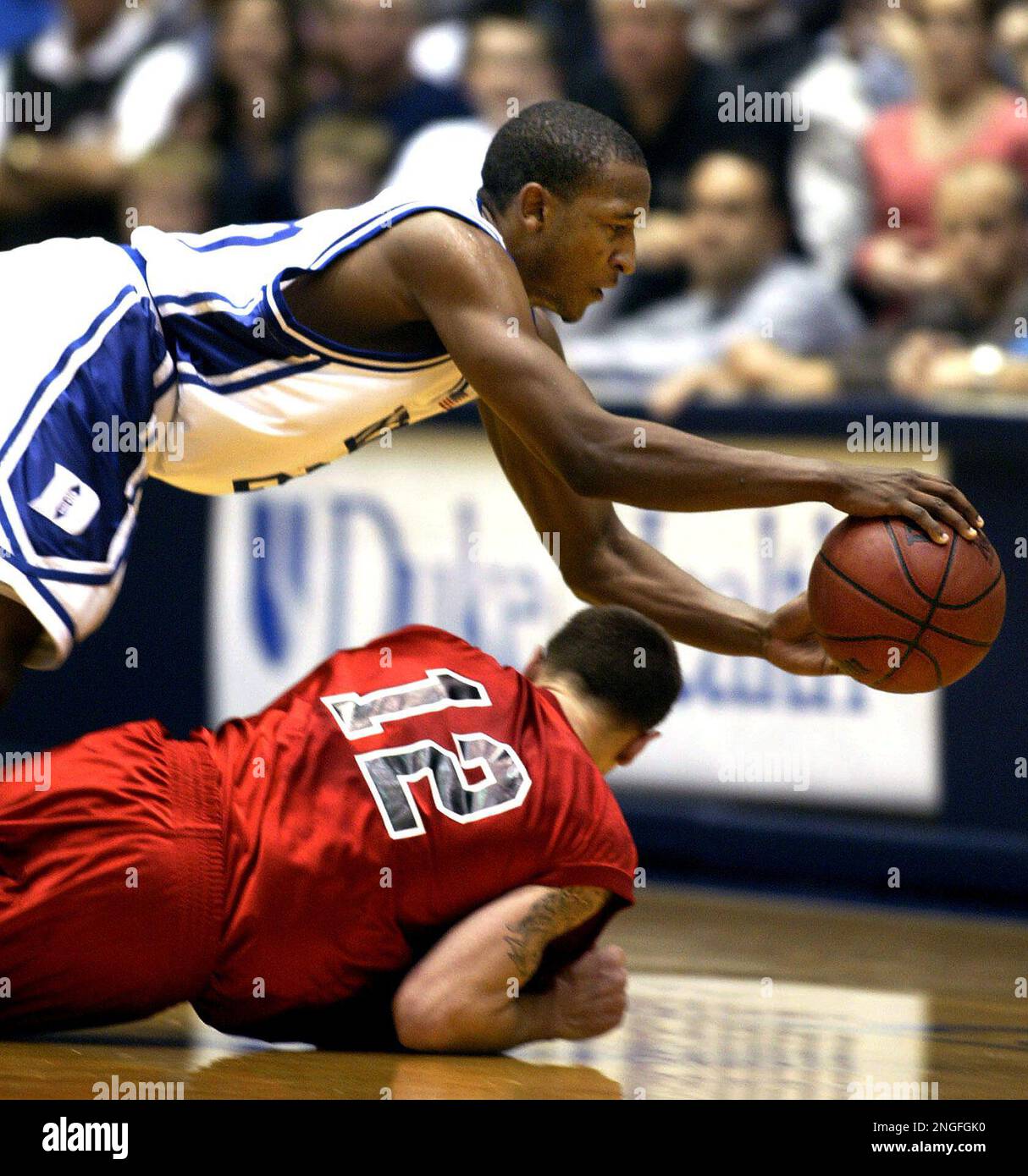 Duke's Chris Duhon, top, dives over Davidson's Kenny Grant (12) for a ...