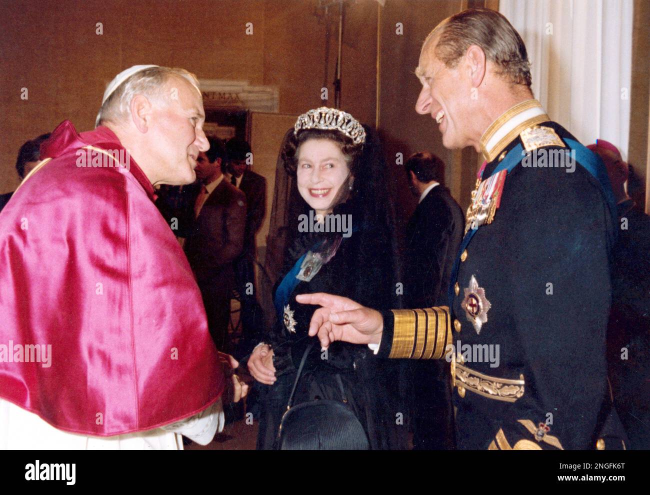 Britain's Queen Elizabeth II, turns at smiles at her husband Prince ...