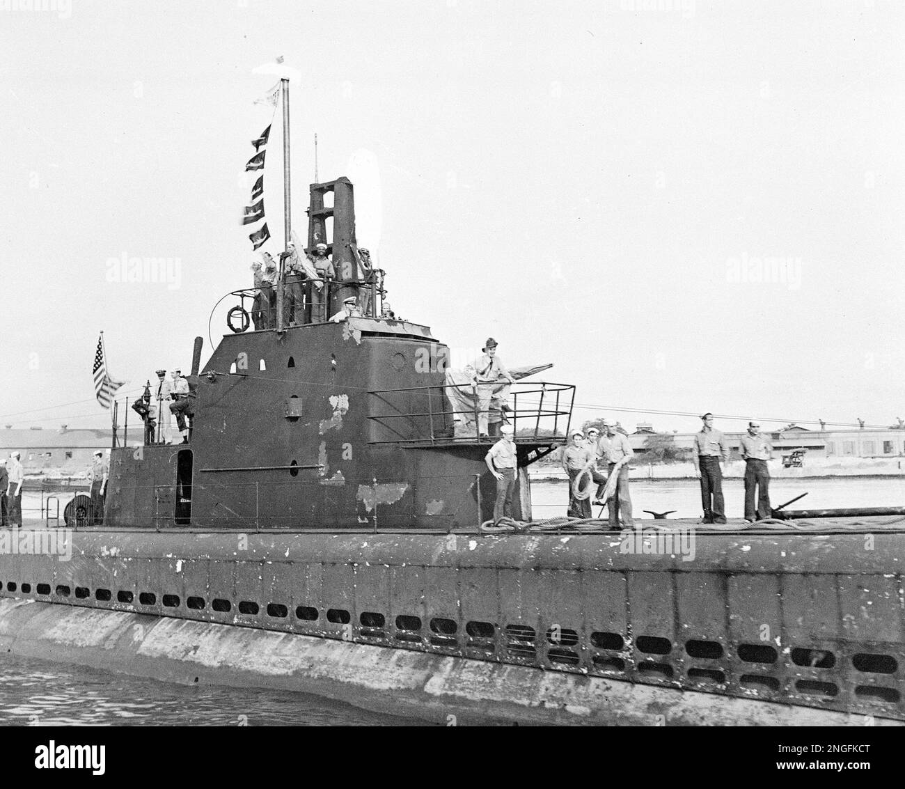 A U.S. submarine, with five victory flags flying to indicate the number ...