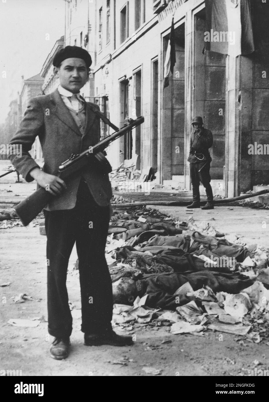 A young Hungarian rebel, holding a submachine gun, stands near a long ...