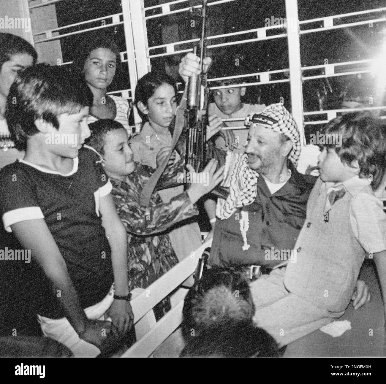 Palestinian leader Yasser Arafat sits with a group of refugees in a ...