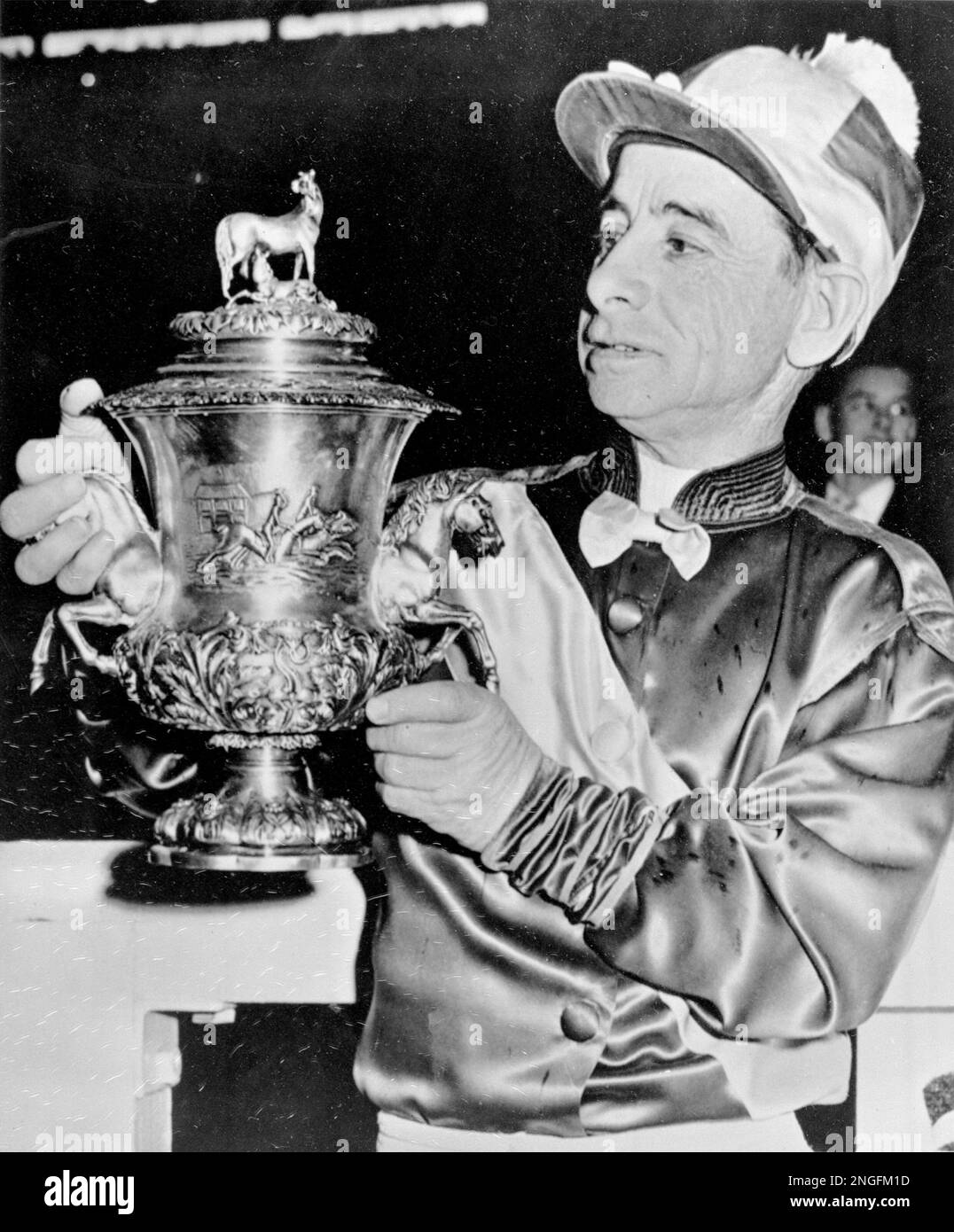 Jockey Johnny Longden admires the 116-year-old trophy presented at a ...