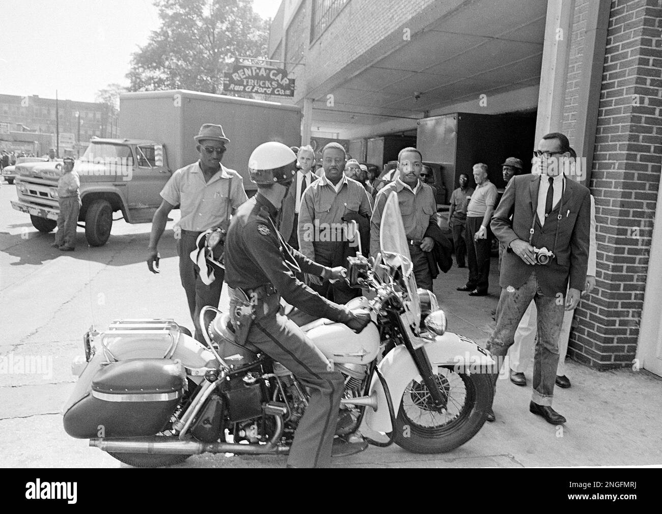 A police officer on a motorcycle rolls his machine in front of civil ...