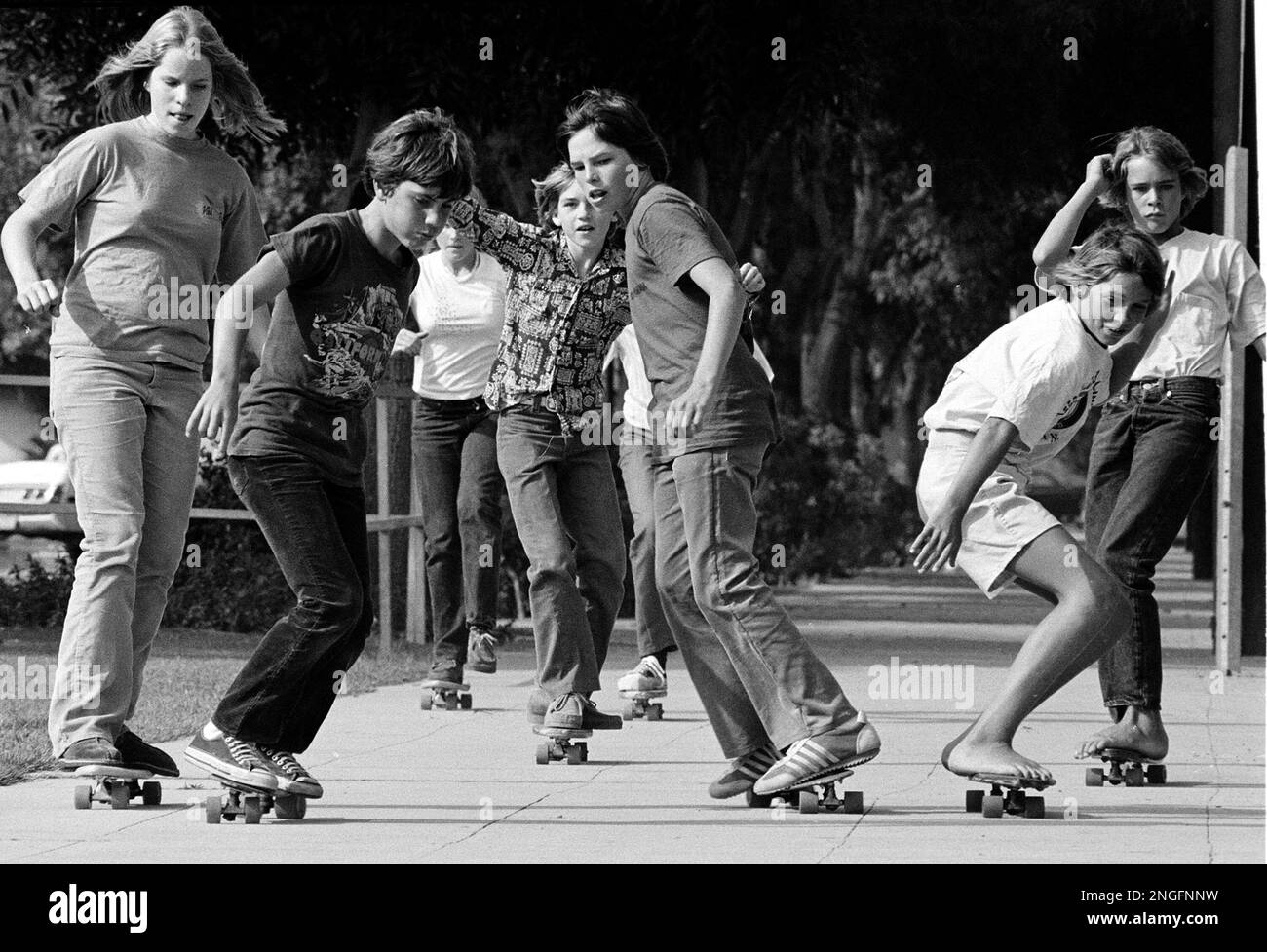 Skateboard enthusiasts stage an impromptu race down a suburban sidewalk ...